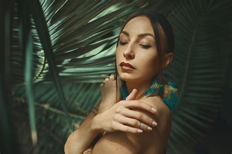 이국적인 야자수의 배경에서 포즈를 취하는 아름 다운 젊은 여자는 떠난다 향수 화장품 개념입니다 귀걸이에 대한 스톡 사진 및 기타 이미지 Istock
