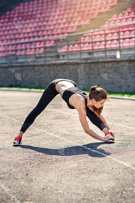 健身女孩在训练前在健身房做伸展运动。