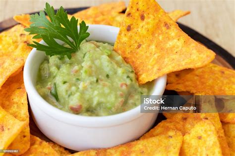 과카몰리 소스를 곁들인 흰 그릇과 나무 판에 옥수수 나초가 있습니다 45도 뷰 0명에 대한 스톡 사진 및 기타 이미지 0명