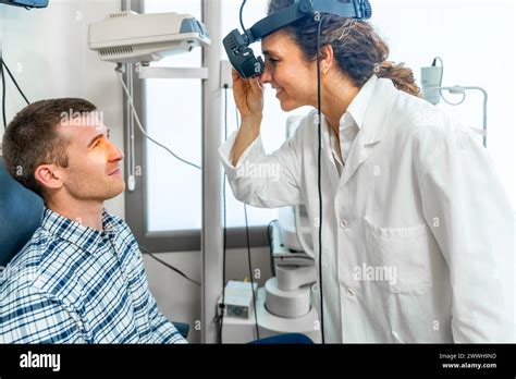 Female Ophthalmologist Checking The Retina Of A Patient Using The Light