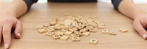 Woman Puts Hands On Sides Of Wooden Cubes Pile Lying On Table Stock