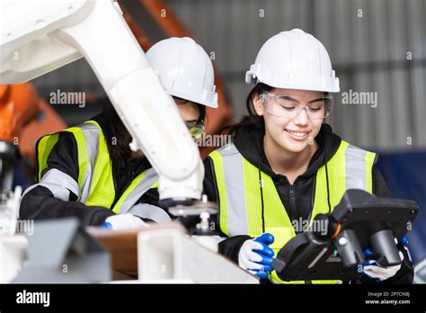A Team Of Female Engineers Meeting To Inspect Computer Controlled Steel Welding Robots Plan For