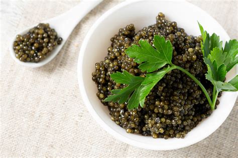 검은 캐비어 세라믹 그릇과 밝은 배경에 세라믹 숟가락에 검은 철갑상어 캐비어 유용한 진미 텍스트 공간이 있는 상단 보기 거친 필름 효과에 대한 스톡 사진 및 기타 이미지