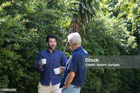 행복한 노인과 성인 남자가 걷고 커피나 차를 마시는 야외 정원 공원에서 함께 시간을 보내는 행복한 두 남자 행복한 가족 휴일 및