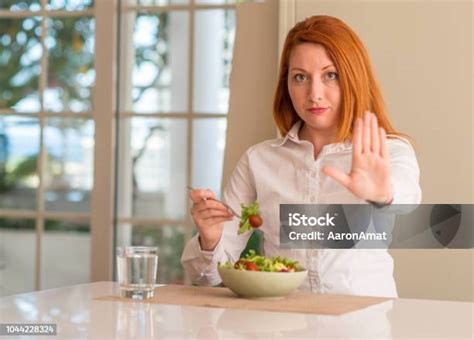 빨간 머리 여자 먹는 신선한 녹색 샐러드 집에서 열 손 심각 하 고 자신감 표현 방어 제스처 정지 표시를 하 고 가정 생활에 대한 스톡 사진 및 기타 이미지 Istock