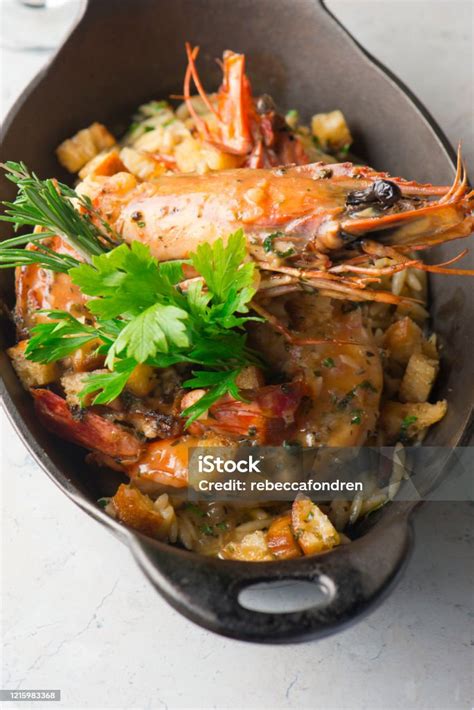 점보 새우 마늘 버터 샬롯 화이트 와인에 구운 팬 고전적인 전통 그리스 지역 민족 요리 찐 유기농 채소 브로콜리 당근 콜리플라워 레몬과 이탈리아 파슬리로 장식되어 제공됩니다