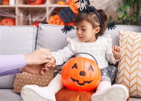 Adorable Hispanic Girl Wearing Halloween Costume Drawing On Hand At
