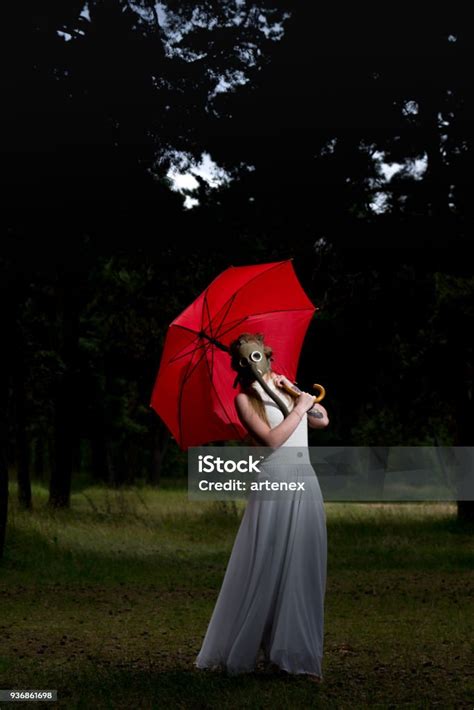 현대 패션 개념입니다 빨간 우산와 가스 마스크 백인 백색 여성 모델 서 흰색에 긴 머리를 가진 아름 다운 여자 자연에서 휴식 드레스와 날씨를 즐깁니다 개념에 대한 스톡 사진