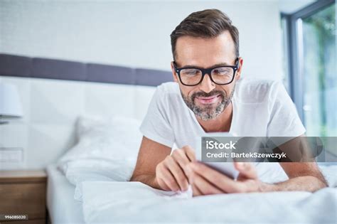 행복 한 사람이 침대에 누워 하 고 아침에 전화를 사용 하 여 남자에 대한 스톡 사진 및 기타 이미지 남자 스마트폰 침대 Istock