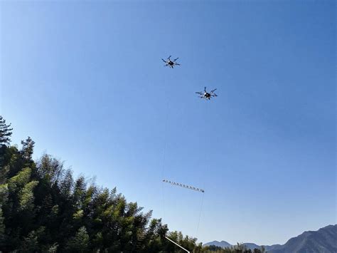 衢州山区飞起“大力神”，两架无人机联手吊起千斤重物建电站