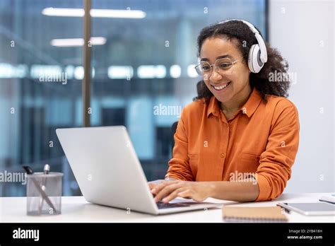 Female Programmer Wearing Headphones Coding New Software On Laptop