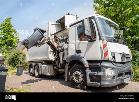 Automated Garbage Collection Hydraulic Side Loader Of A White Garbage Truck Grabs The Garbage