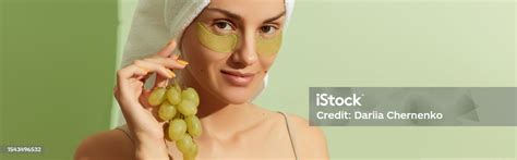 파스텔 녹색 배경에 포도씨 기반의 눈 패치를 사용하는 여성 자연 지속 가능한 스킨케어 메이크업 화장품에 대한 스톡 사진 및 기타 이미지 메이크업 화장품 포도 여름