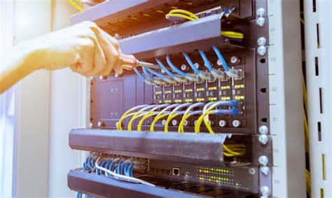 Premium Photo Technician Connecting Network Cable To Switch