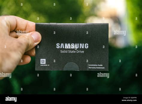 PARIS FRANCE AUG 3 2018 Man Hand Holding Packaging Instruciton Of NVME PCIE SSD Hard Drive