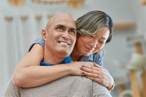 결혼 생활이나 관계에서 지지 미소 및 헌신을 위해 가정에서 부부 포옹 및 사랑 사람들 주말에 포옹하고 행복하고 애정을 나누고 유대감을 위해 함께 그리고 연결 또는 보살핌을