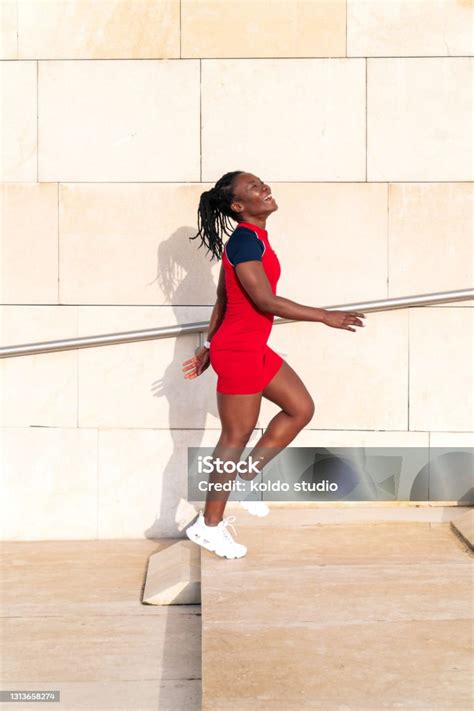 화려한 빨간 드레스를 입은 밝은 베이지색 벽에 도시의 거리에서 행복하게 미소 짓는 아프로 머리를 한 흑인 소녀 35 39세에 대한 스톡 사진 및 기타 이미지 Istock