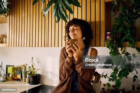 현대적인 나무 악센트와 무성한 관엽 식물로 조명이 밝은 주방에서 모닝 커피의 향기를 음미하고 평온의 순간을 포용하고 일상 생활에서 마음 챙김과 단순한 즐거움의 기쁨을