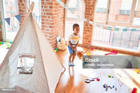 유치원에서 많은 장난감 주위에 막대기로 말 장난감을 가지고 노는 아름다운 아프리카 계 미국인 유아 갈색에 대한 스톡 사진 및 기타 이미지 Istock