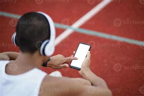 Asian Man Sportsman Fit Body Wearing White Headphone And Using Mobile