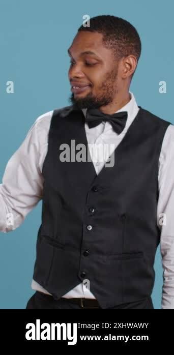 Vertical Video Doorkeeper Bellhop Pointing At Something To Left Or Right Sides Indicating The