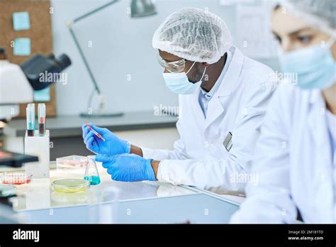 Side View Portrait Of Black Man Working In Modern Laboratory And Doing