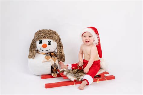 눈사람이 있는 흰색 고립된 배경에 산타 모자를 쓰고 빨간 썰매에 앉아 있는 어린 소녀 2021년 새해 복 많이 받으세요 텍스트를 위한 공간 12월에 대한 스톡 사진 및 기타