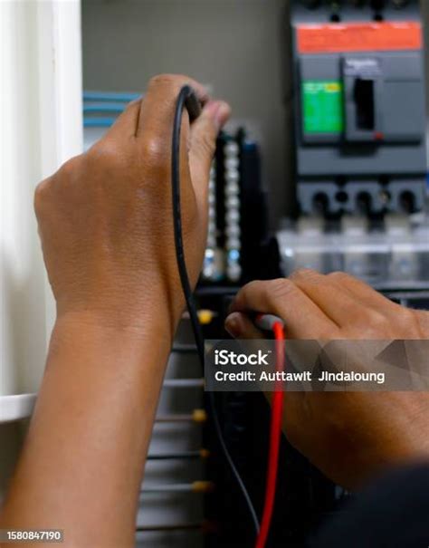 전기 캐비닛 제어에서 전력 전선의 전압과 전류를 측정하는 전기 기술자 작업 테스터 전문 인력은 도구 시운전 테스트 또는 보호 시스템 회로 점검을 사용합니다 건설 산업에 대한