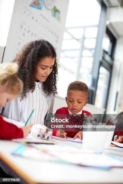 두 명의 유아 학교 어린이 그들의 여 교사 교실에 테이블에 앉아 낮은 각도 영국에 대한 스톡 사진 및 기타 이미지 영국 교사 교육 관련 직업 교육 Istock