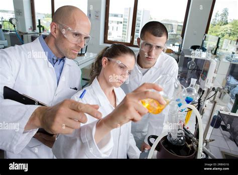 Laboratory Workers Experimenting Different Liquid In Flask Containers