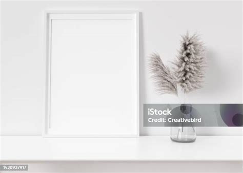 흰색 선반에 서있는 빈 수직 액자 프레임 모형 사진 포스터를위한 공간을 복사하십시오 아트웍에 대한 템플릿입니다 보기를 닫습니다 꽃병에 팜파스 잔디 3d 렌더링 개념에 대한