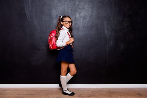 크기 몸 길이 좋은 스마트 귀여운 세련 된 사랑 스러운 작은 소녀 가방 흰 블라우스 셔츠와 블루 스커트에 곱슬 땋은 전체 검은