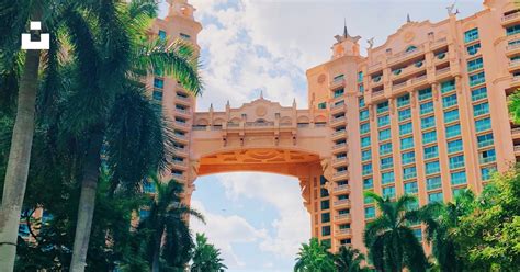 흰 셔츠를 입은 여자가 고층 건물 근처의 분수 옆을 걷고 있습니다 사진 Unsplash의 무료 이름 없는 길 이미지