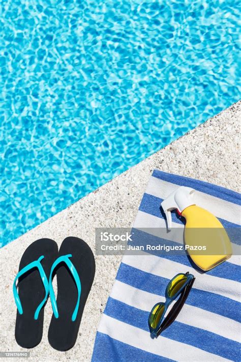 수영장 가장자리에 있는 파란색과 흰색 줄무늬 수건에 플롭 자외선 차단제 스프레이 선글라스를 뒤집습니다 공간을 복사합니다 수건에 대한 스톡 사진 및 기타 이미지 Istock