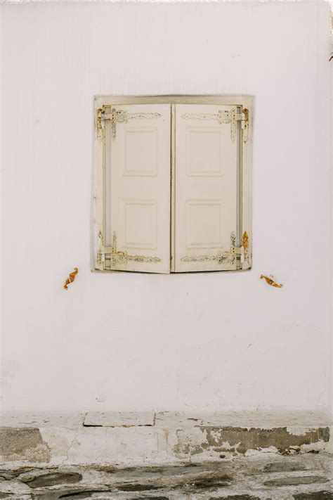 창문이 있는 흰 벽과 그 앞에 벤치가 있습니다 사진 Unsplash의 무료 회색 이미지