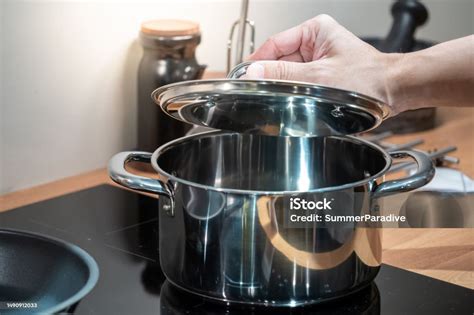 쇼핑 주방 용품 개념 남성의 손이 스테인리스 냄비를 열고 주방용품 쇼룸 매장의 전기 호브에 불을 붙였다 집에서 가정용 주방용 조리기구 구입 가열장치에 대한 스톡 사진 및