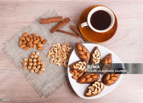 디저트 접시에 아몬드와 캐슈 너트와 작은 케이크 감자 커피 계피 아몬드 헤이즐넛 리넨 냅킨에 캐슈 한 잔 정물 공간을 복사합니다 감자 요리에 대한 스톡 사진 및 기타 이미지