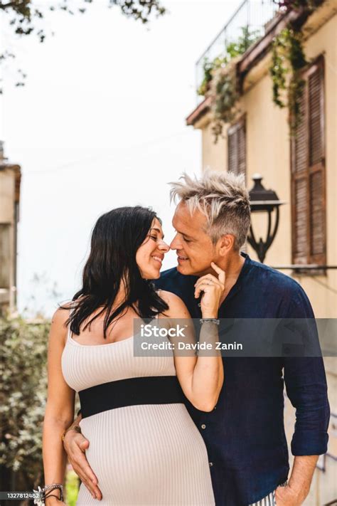 행복한 부부 임신 한 여자와 함께 서로의 눈을 보고 마을에서 여름 방학 동안 사진을 포즈 젊은 아내와 남편은 아기를 기대 임신과 사랑 개념 2명에 대한 스톡 사진 및 기타