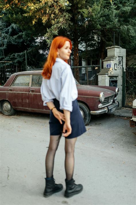 Burgundy Car On A Parking Lot Behind A Redhead Posing In Shorts · Free