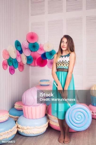 파란색 드레스를 입고 아름 다운 소녀 마카롱의 장식과 스튜디오에 손에 거 대 한 사탕을 개최 공간에 복사 합니다 감정에 대한 스톡 사진 및 기타 이미지 Istock