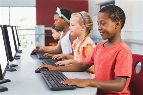 Crianças Da Escola Usando O Computador Na Sala De Aula Foto Premium