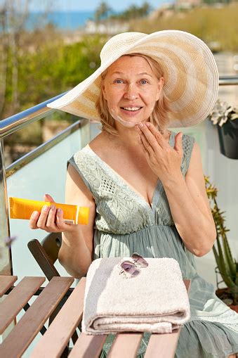 바닷가에 있는 호텔 테라스에 있는 여성 무두질 어깨에 선 크림을 적용 하는 여자 자외선 차단 스킨 및 바디 케어 바다에 대한 스톡 사진 및 기타 이미지 Istock