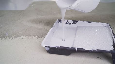 나무 주걱 클로즈업 페인트 트레이에 페인트를 부어 Diy는 벽을 그리는 예술가 자신은 집의 수리 장식을합니다 작업자가 믹싱 볼에