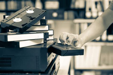 Close Up Hand Chooses And Put Or Insert Video Cassette Tape Vhs On