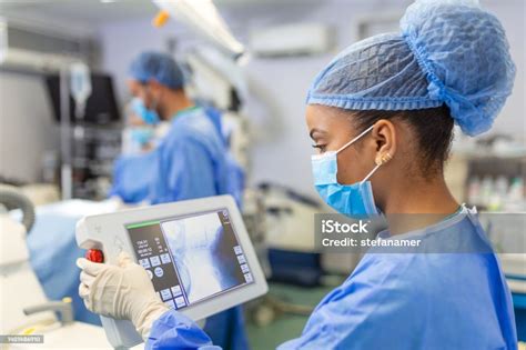 수술실에서 수술 마스크를 착용한 여성 외과 의사가 3d 이미지 유도 수술 기계를 사용하여 간호사에 대한 스톡 사진 및 기타 이미지 간호사 건강관리와 의술 기술