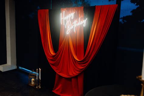 무료 사진 빨간색과 검은색 커튼이 있는 우아한 실내 장식 불이 켜진 네온 생일 축하 표지판