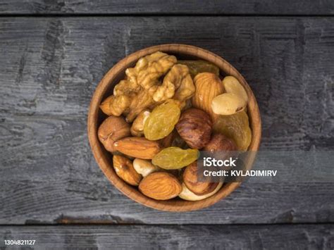 검은 나무 테이블에 견과류와 말린 과일이 혼합 된 나무 그릇 상단에서 보기입니다 0명에 대한 스톡 사진 및 기타 이미지 0명 건강한 식생활 건포도 Istock