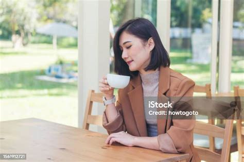 신선도 컵을 들고 커피 숍에서 검은 커피를 마시는 뷰티 여성 커피 애호가 아시아 여성은 녹색 정원 카페에서 컵을 들고 검은 커피 손을 마신다 젊은 여자 미소 얼굴 사랑 음료