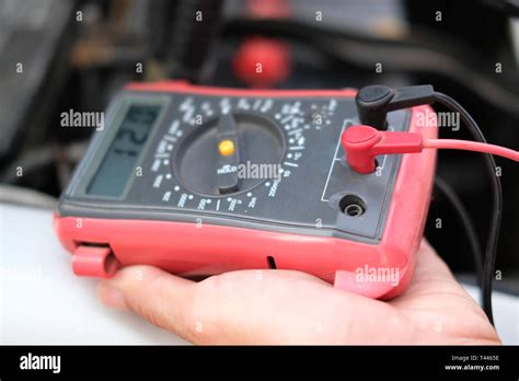 Auto Mechanic Check Car Battery Voltage By Voltmeter Multimeter At Repair Service Station Stock