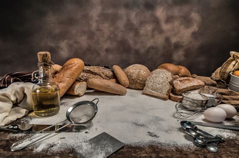 남성 베이커는 빵을 준비합니다 남성 베이커는 밀가루 반죽을 뿌린 다 빵 만들기 최고의 볼 수 있습니다 소박한 스타일 다른 종류의 빵 롤을 테이블 위에서 나무 주방 또는